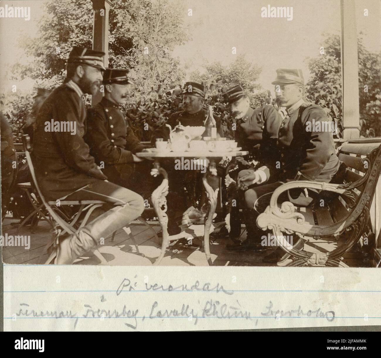 Five officers from the Hälsinge regiment gathered around coffee tables ...