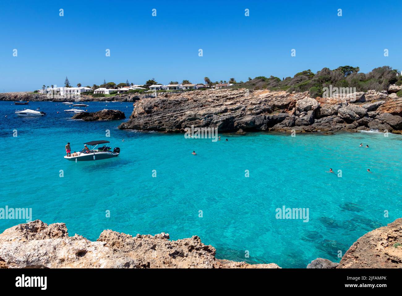 Menorca, Spain - Jun 30, 2022: People bathing in the transparent ...