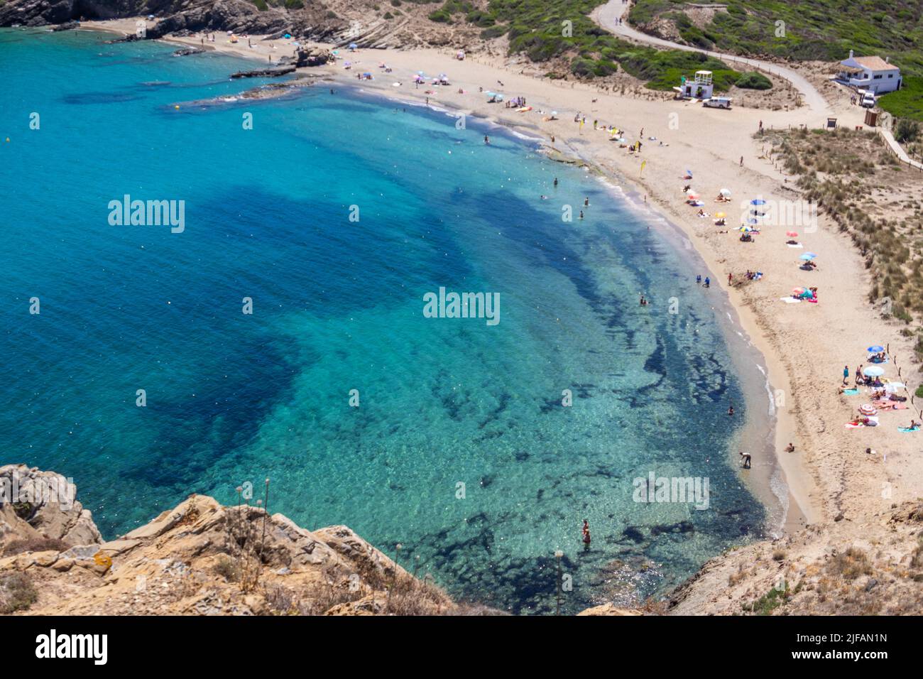 Menorca, Spain - Jun 30, 2022: People bathing in the transparent waters ...