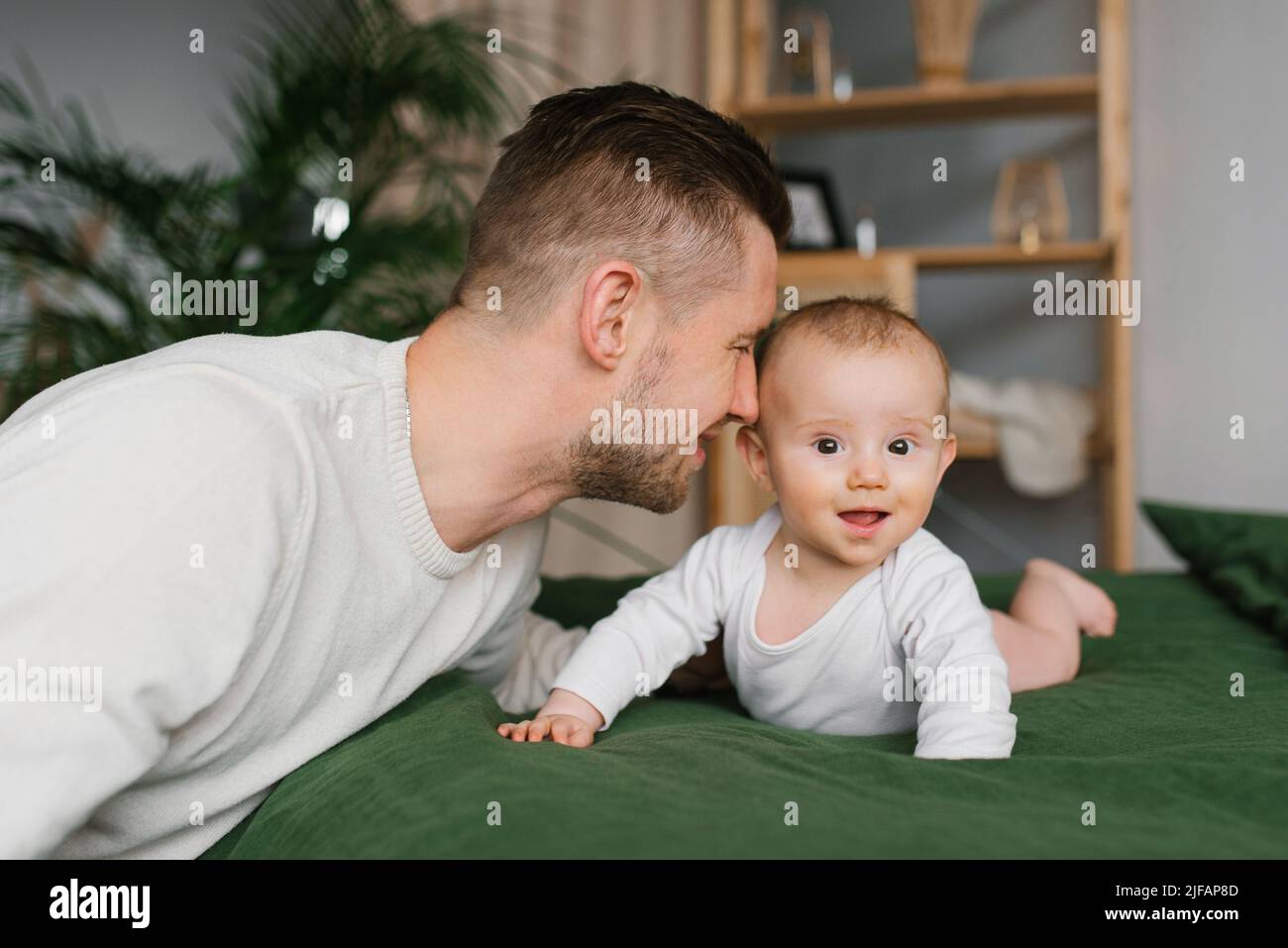 Father and baby son playing on bed in bedroom together Stock Photo - Alamy