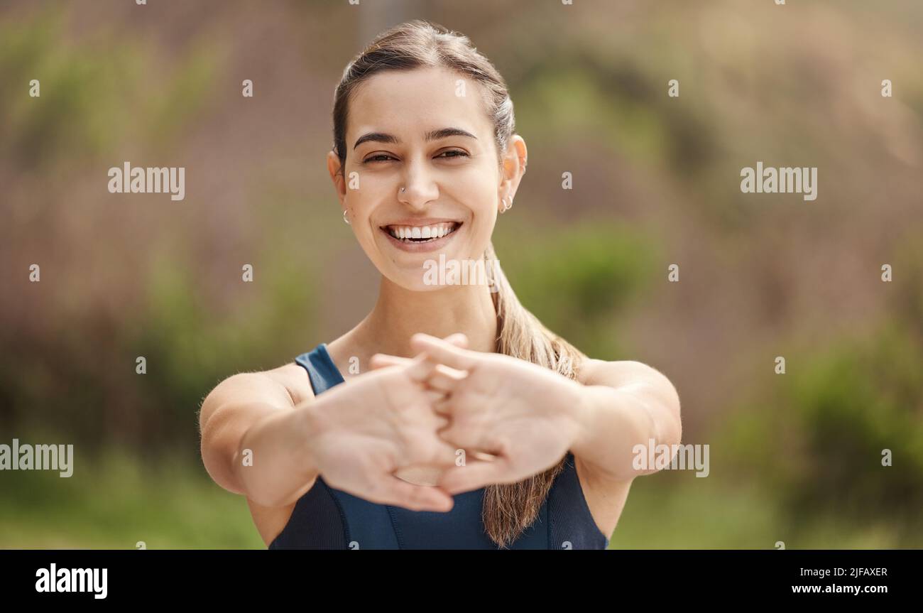 Portrait of one fit young mixed race woman stretching arms for warmup ...