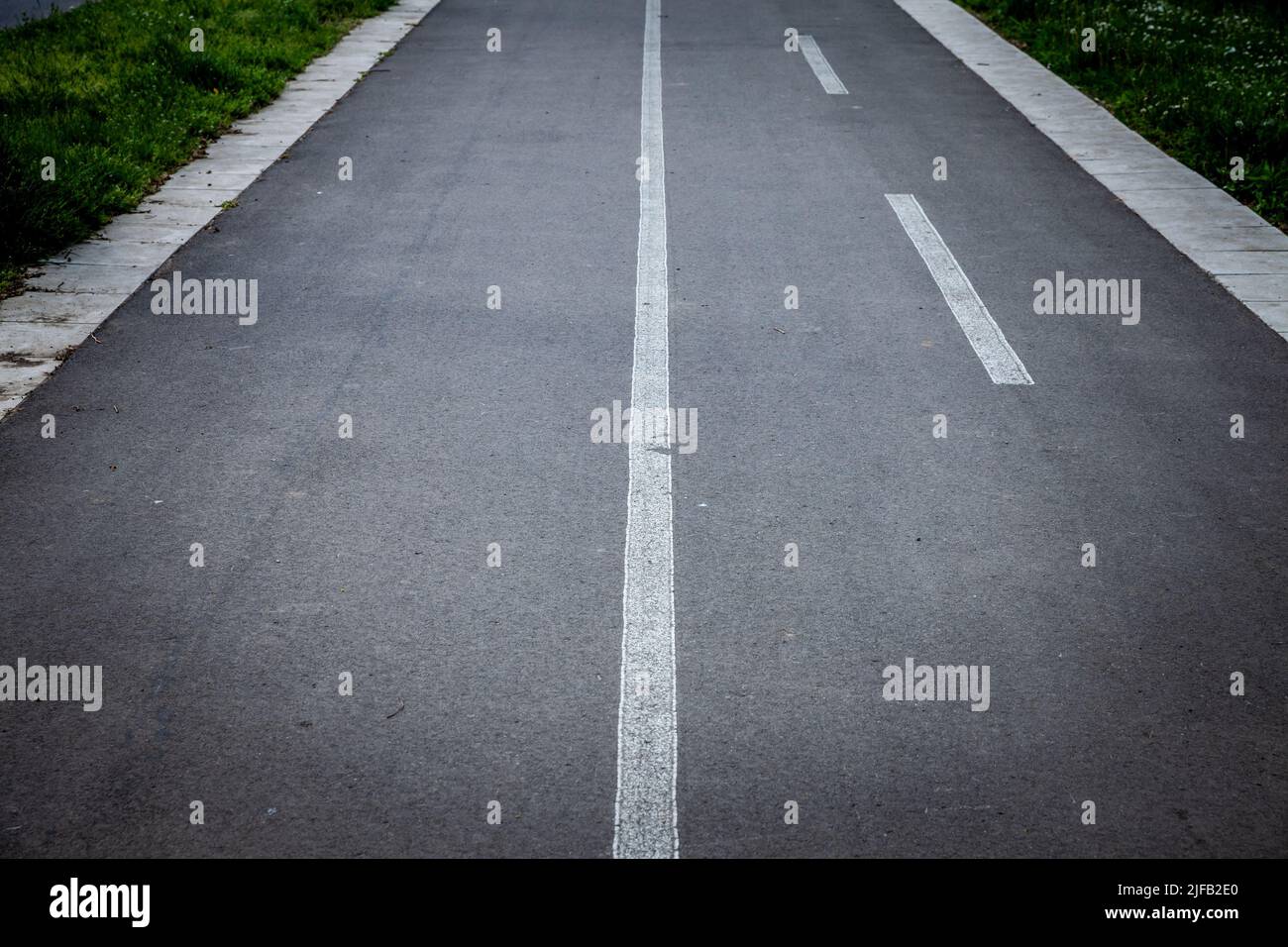 Picture of a bicycle lane with the focus on the white road markings ...