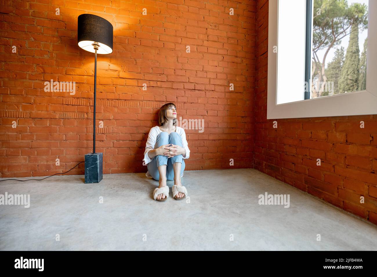 Woman sitting alone at home Stock Photo - Alamy