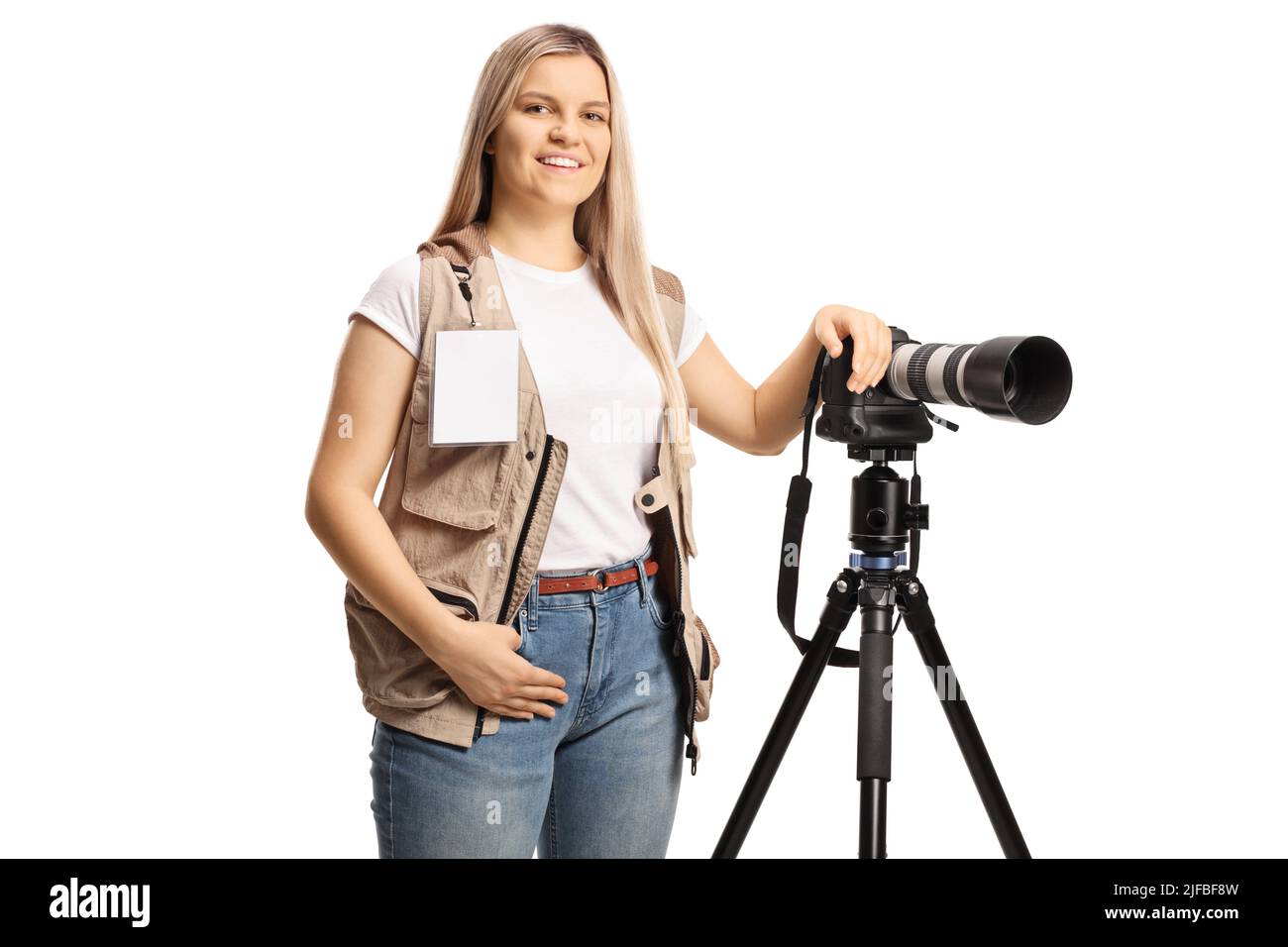 Young female photo journalist working with a camera on a stand isolated ...