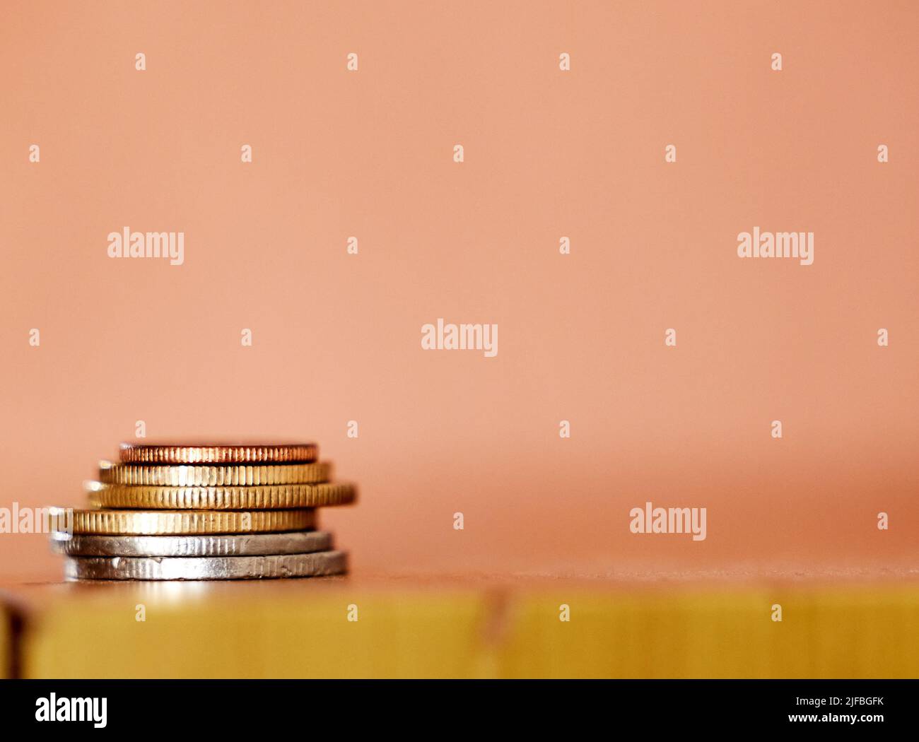 Stack of coins isolated against a brown background. Concept of money ...