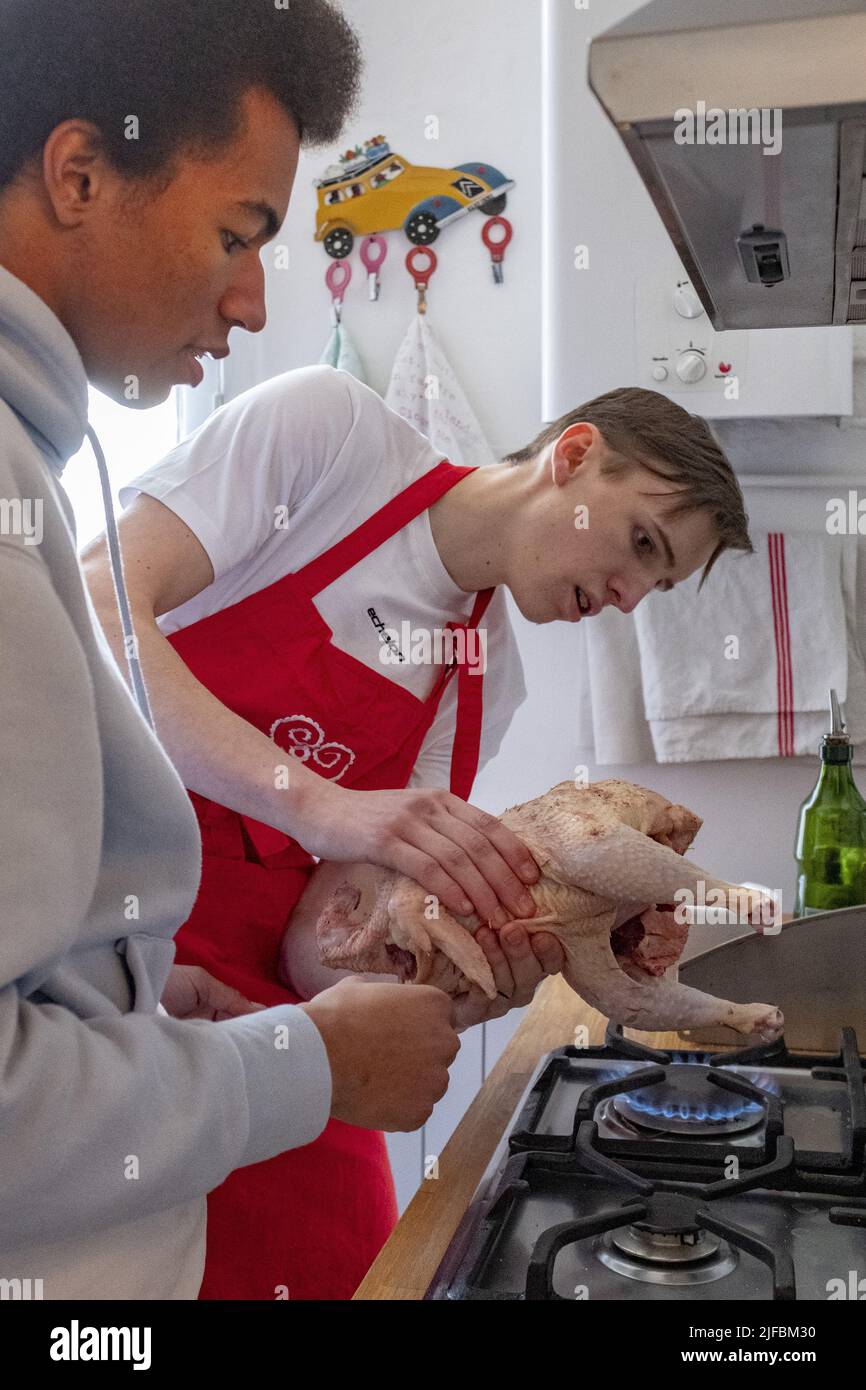 France, Essonne, Montgeron, young men sharing a roommate preparing ...