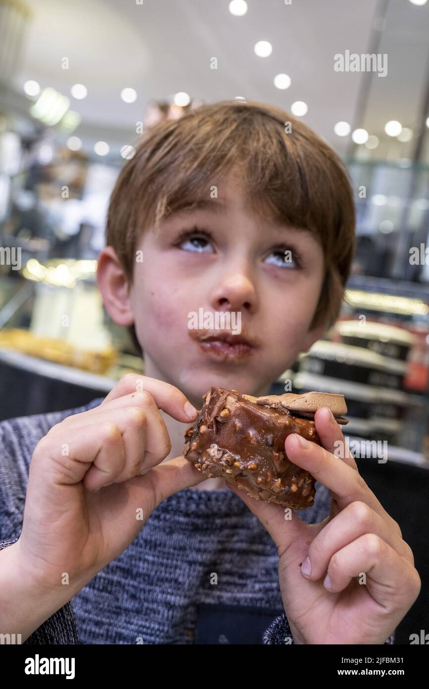 France, Paris, Maison Béchu, jeune garçon dégustant des pâtisseries ...