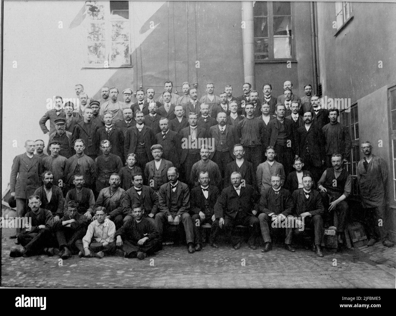 Group portrait of men outside one wing the building at Artillerigården ...