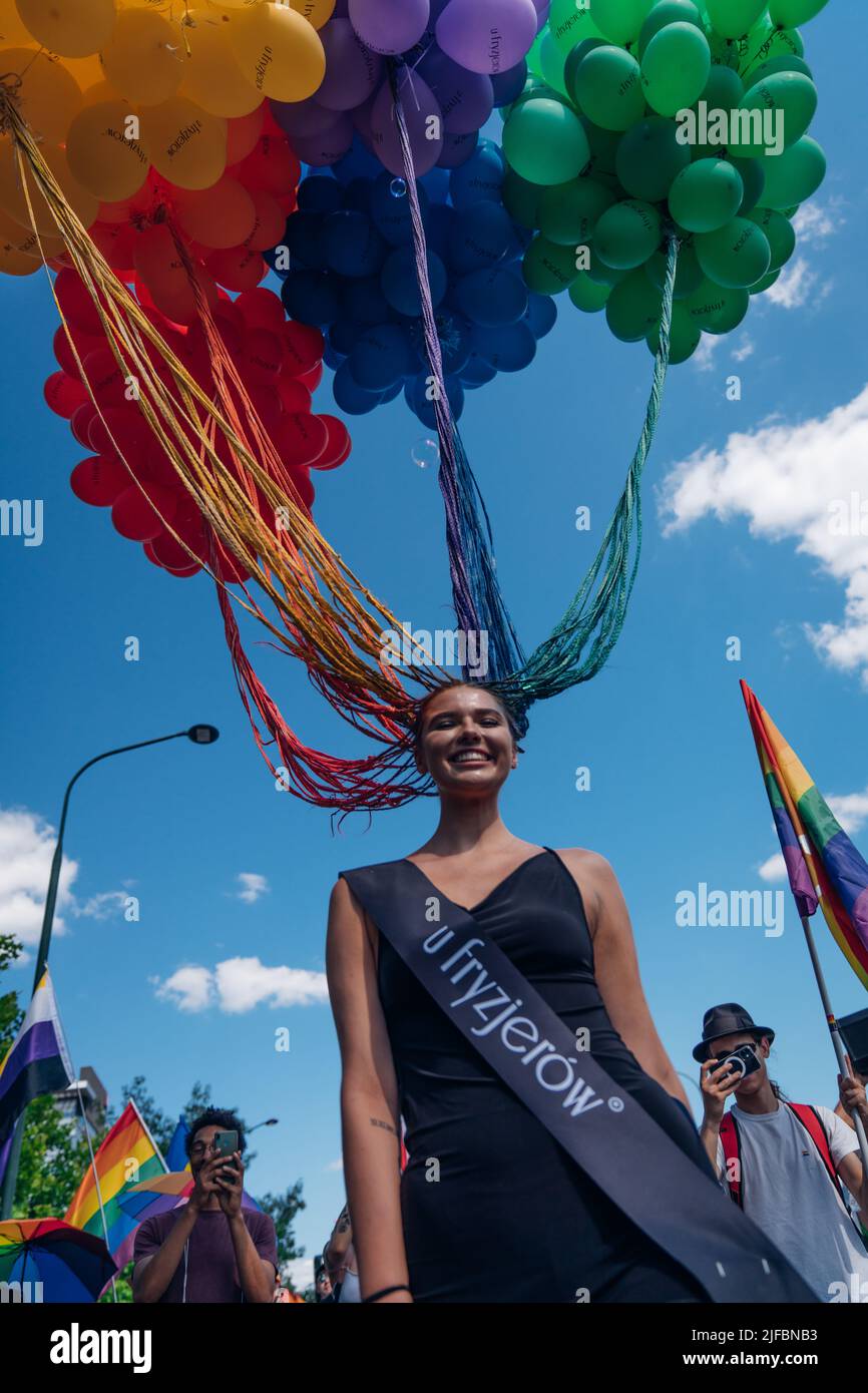 A woman with rainbow balloons in her hair during the Pride Parade in ...