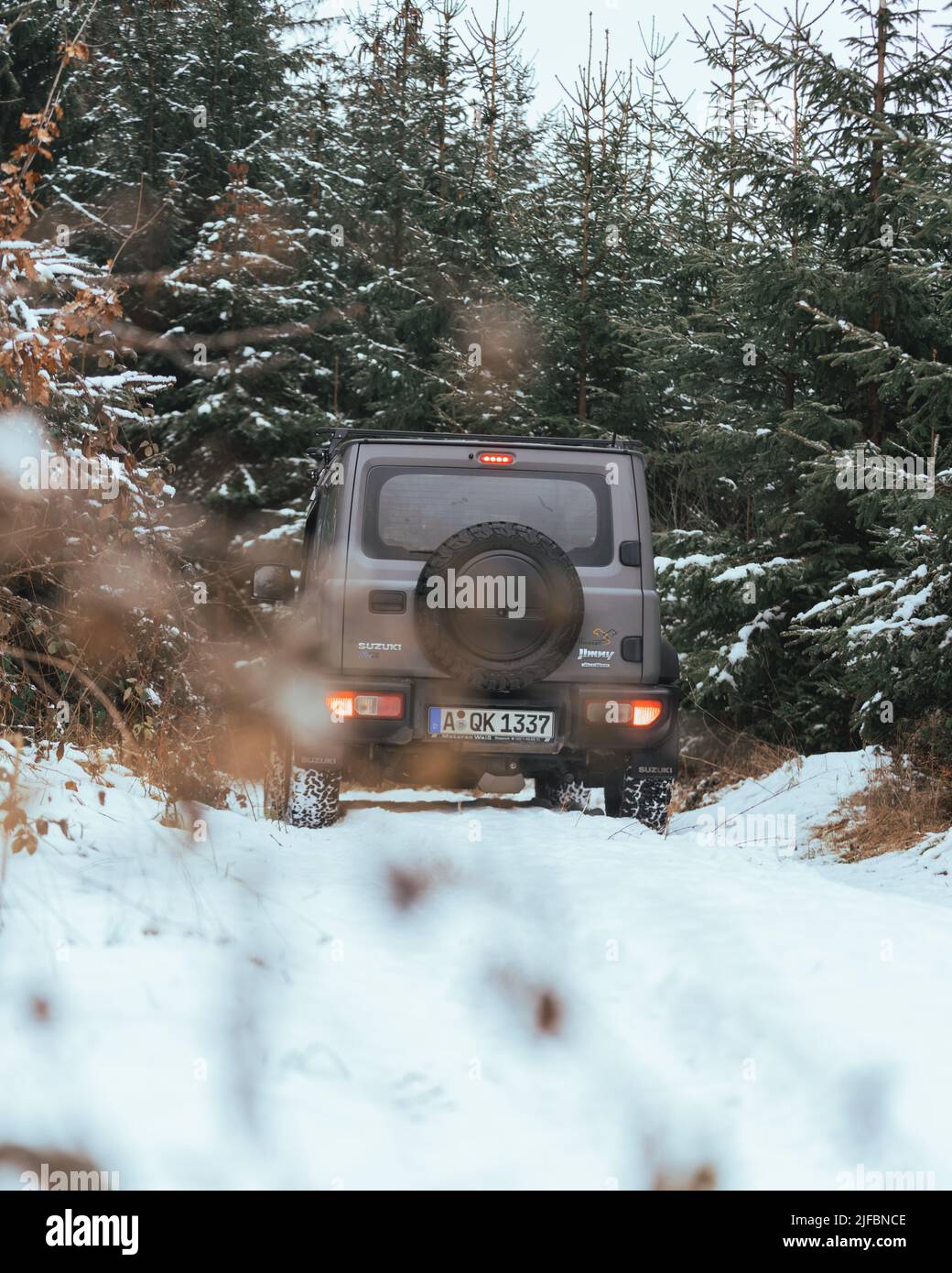 The Suzuki Jimny driving through the winter woods Stock Photo - Alamy