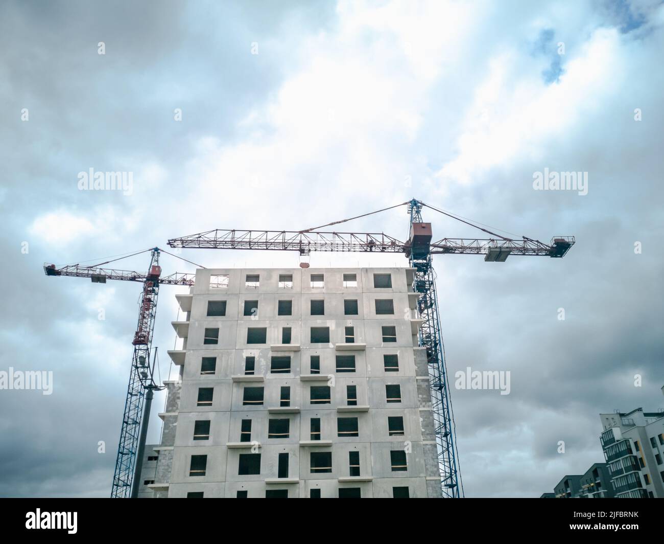 A high-rise panel house under construction with tower cranes Stock ...