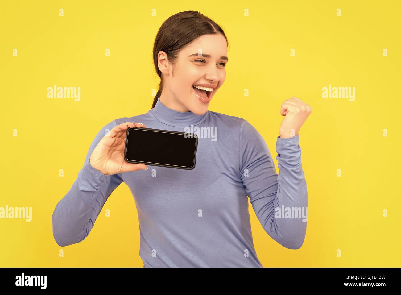 happy successful girl with cellphone showing screen copy space, success ...