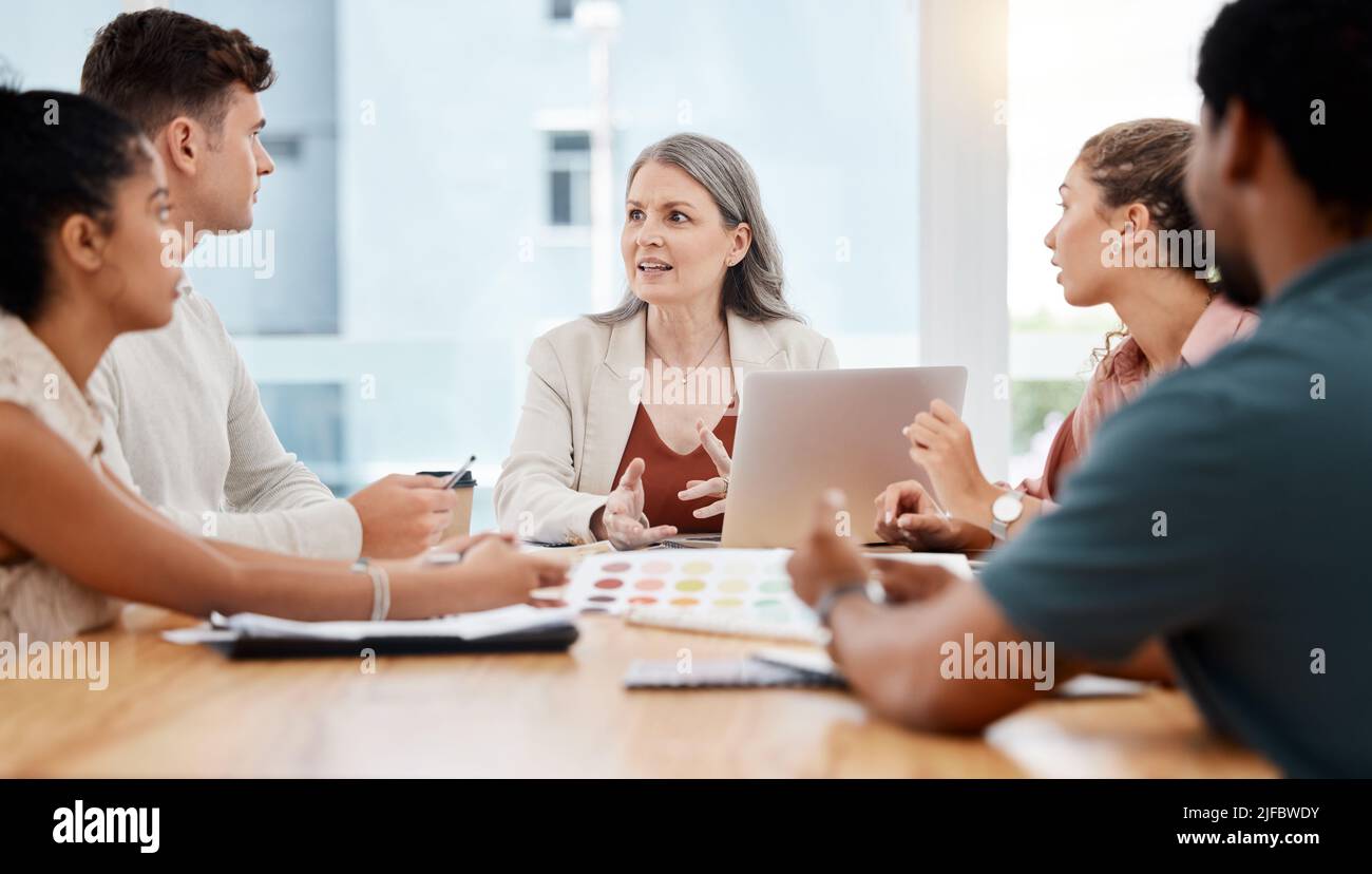 Group of five diverse businesspeople having a meeting in an office at ... Group of five diverse businesspeople having a meeting in an office at ...