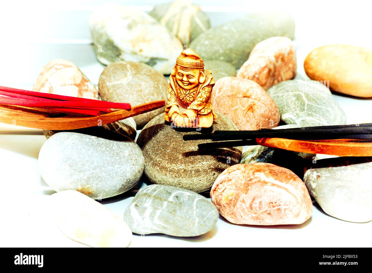 Statuette of a Buddhist monk among incense and various stones Stock ...