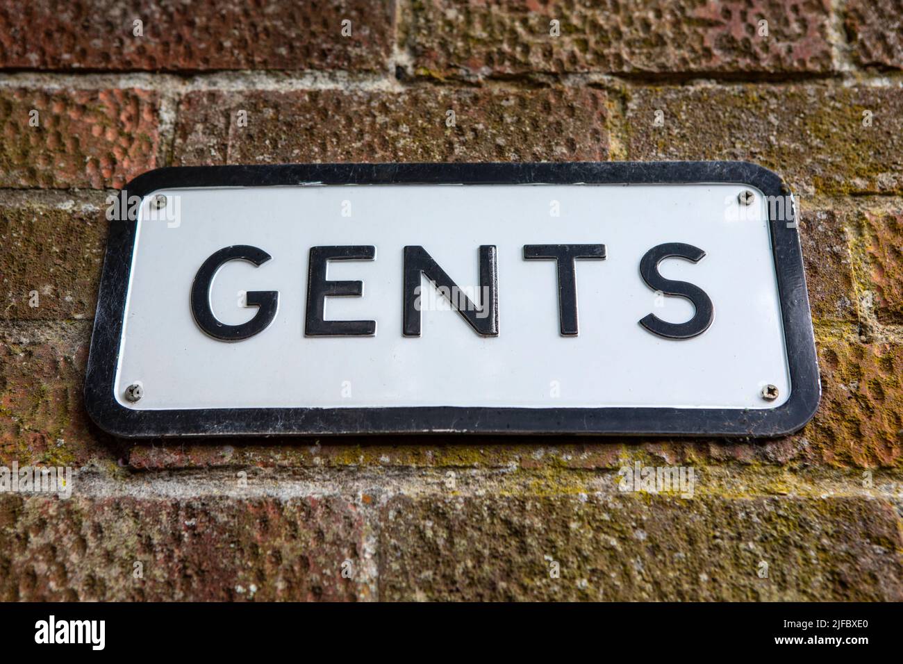 Close-up of a GENTS sign on a brick wall Stock Photo - Alamy
