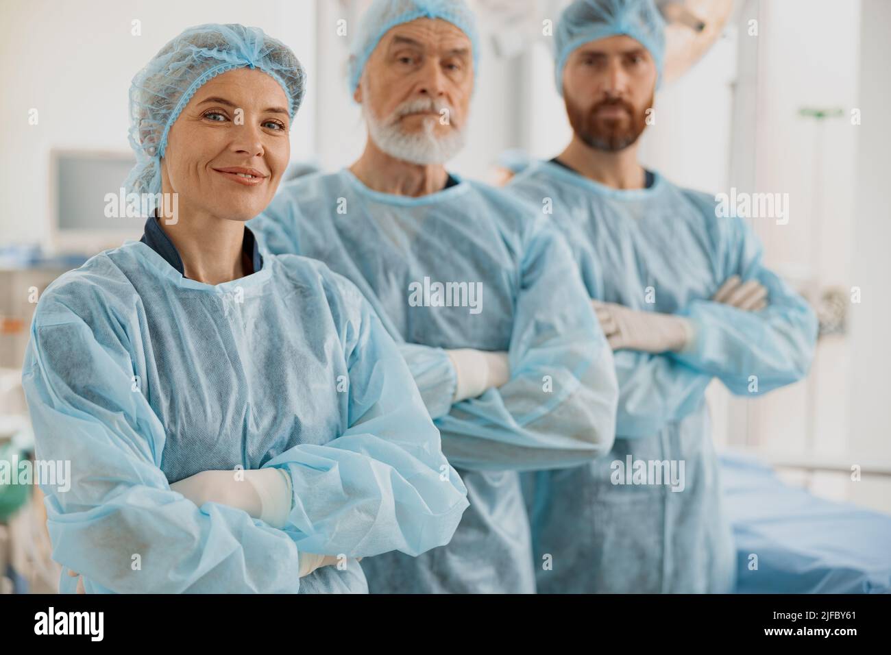 Team of professional surgeons with crossing hands standing in operating ...