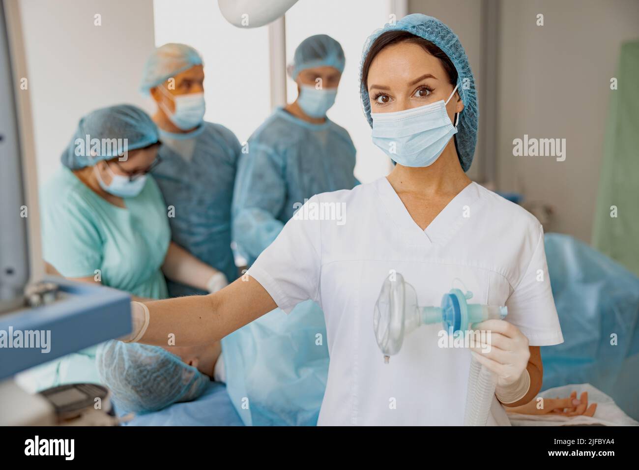 Nurse holding breathing mask for anesthesia standing in operation room ...