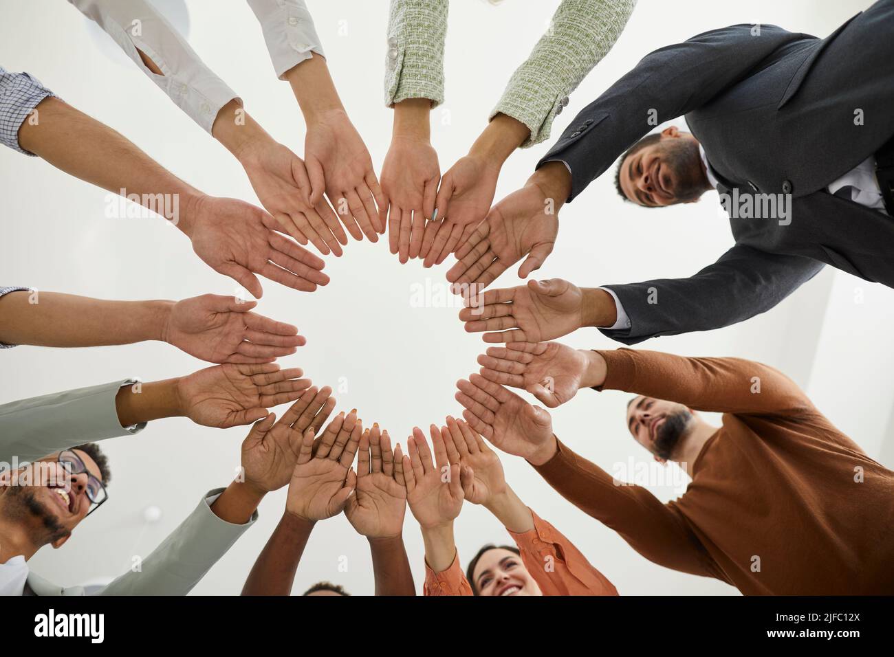 Diverse employees join hands engaged in teambuilding activity Stock ...