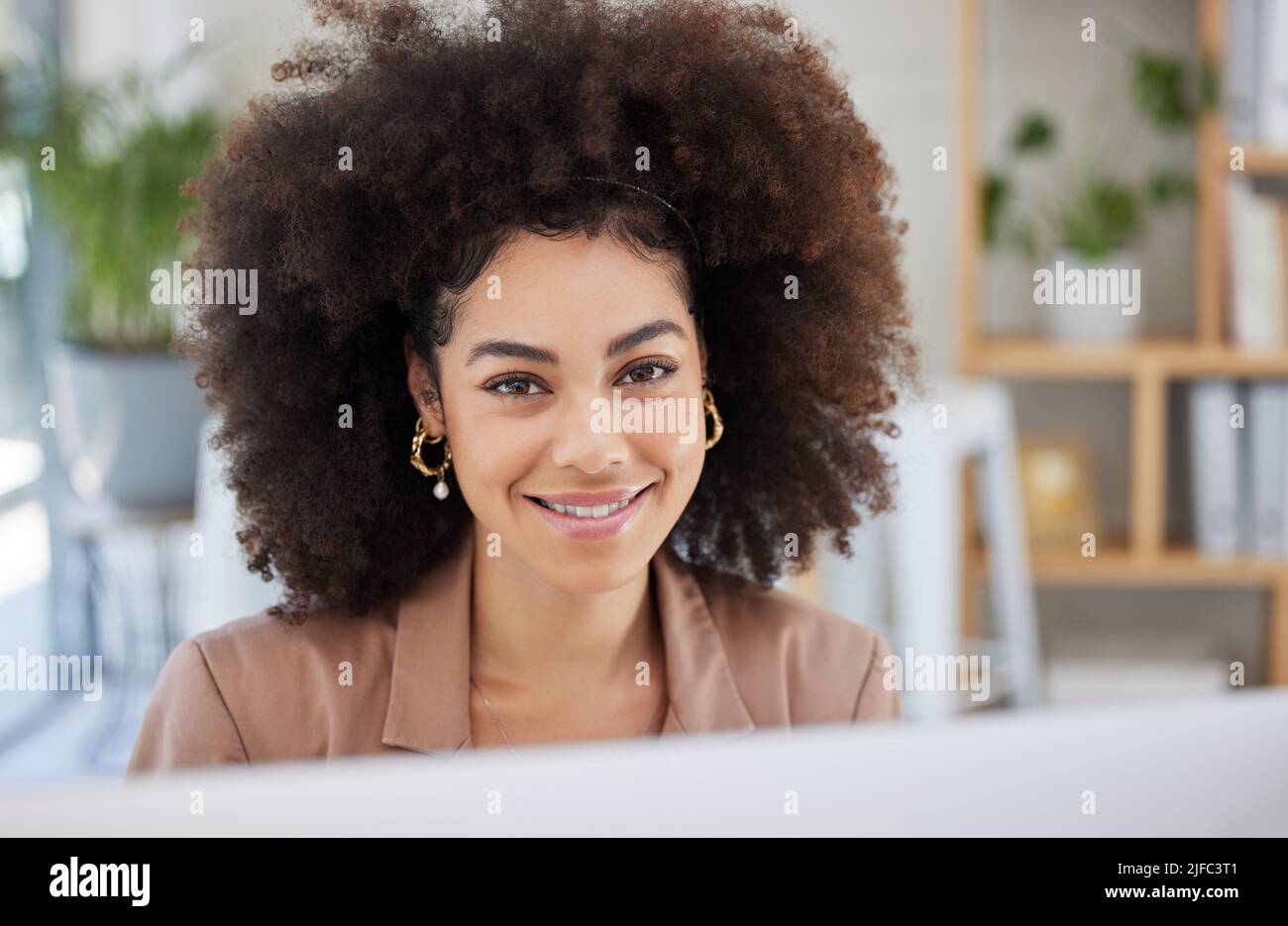 Young happy confident mixed race businesswoman smiling while using a ...