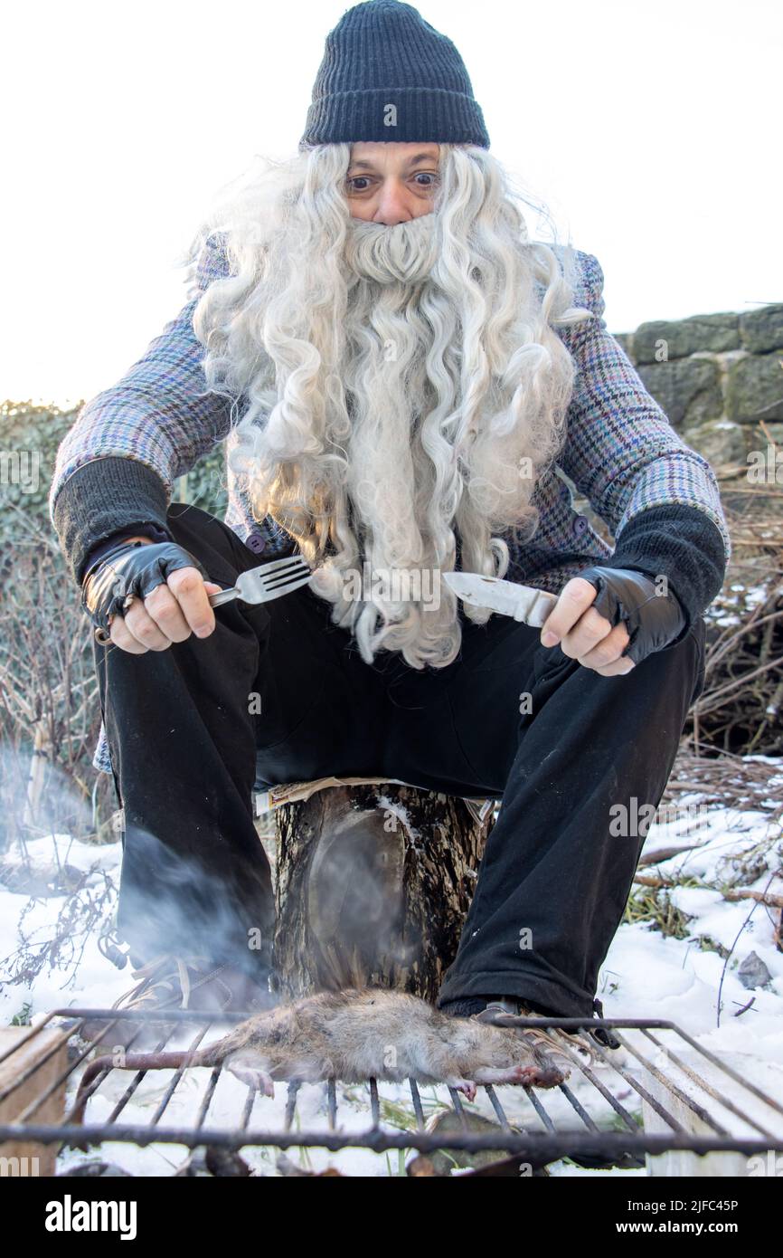 The homeless man grills a rat in the snowy outskirts of the city Stock ...
