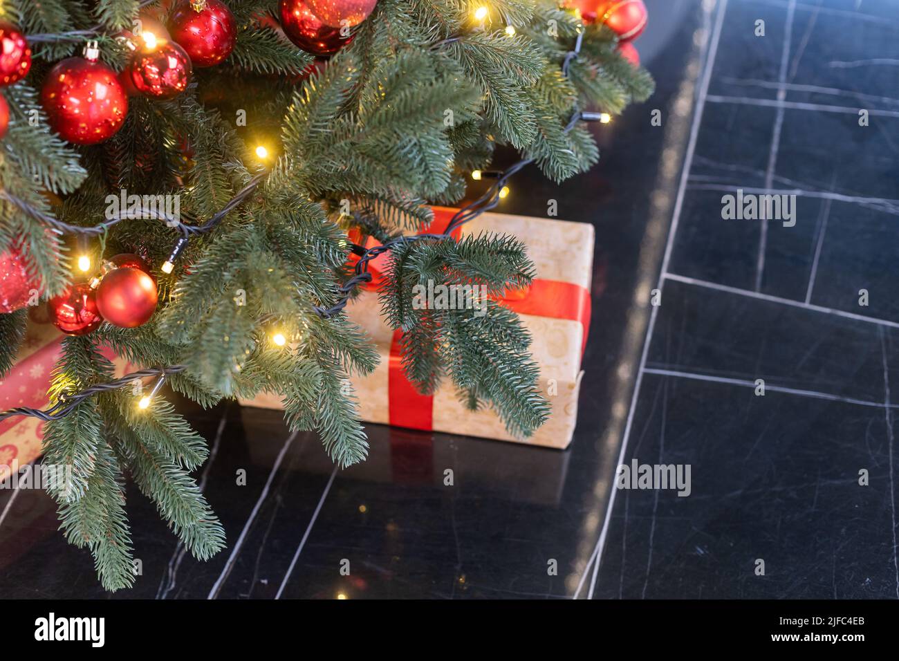 Beautiful Christmas gift boxes on floor near fir tree in room Stock ...