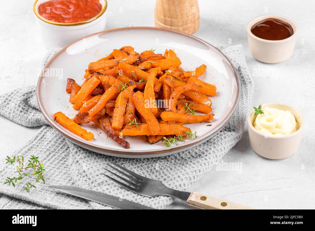Sweet potato fries on a plate with mayo and ketchup, bbq sauce homemade ...