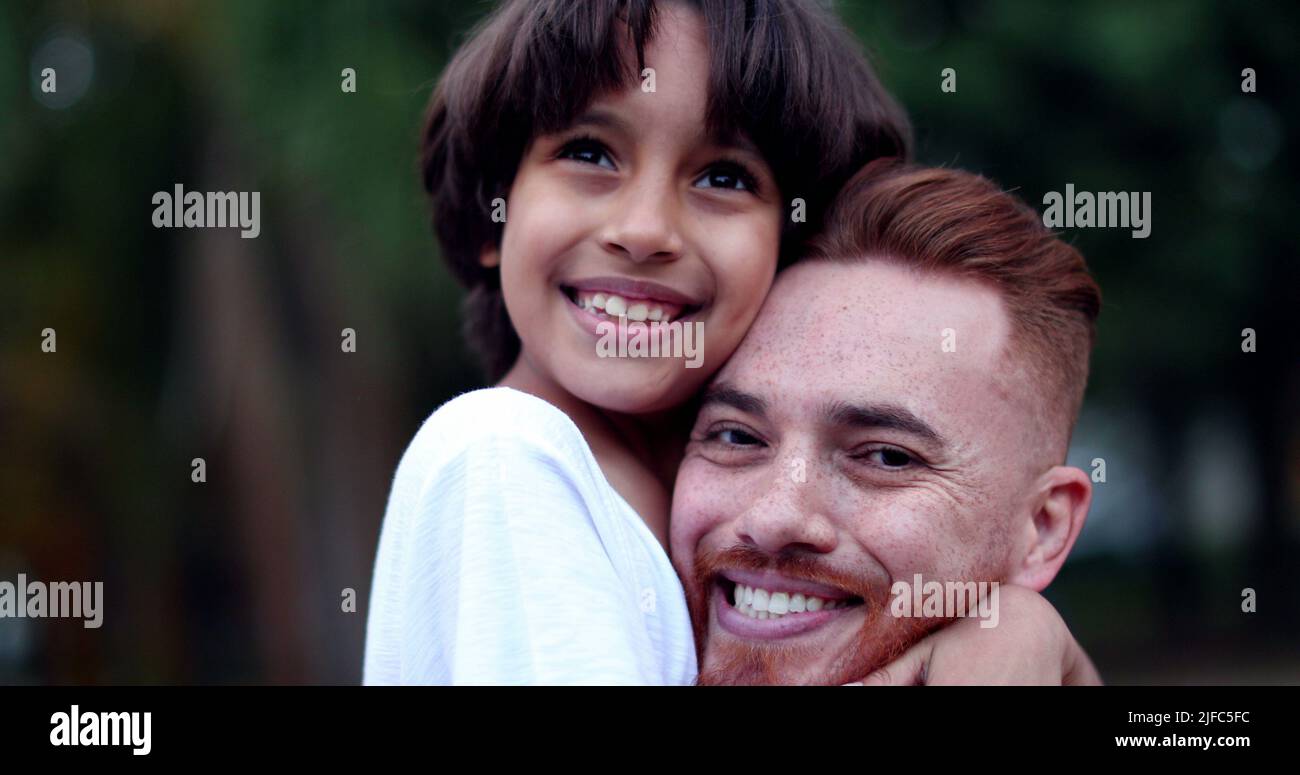 Dad and son embrace huggging each other outside, white father and mixed ...