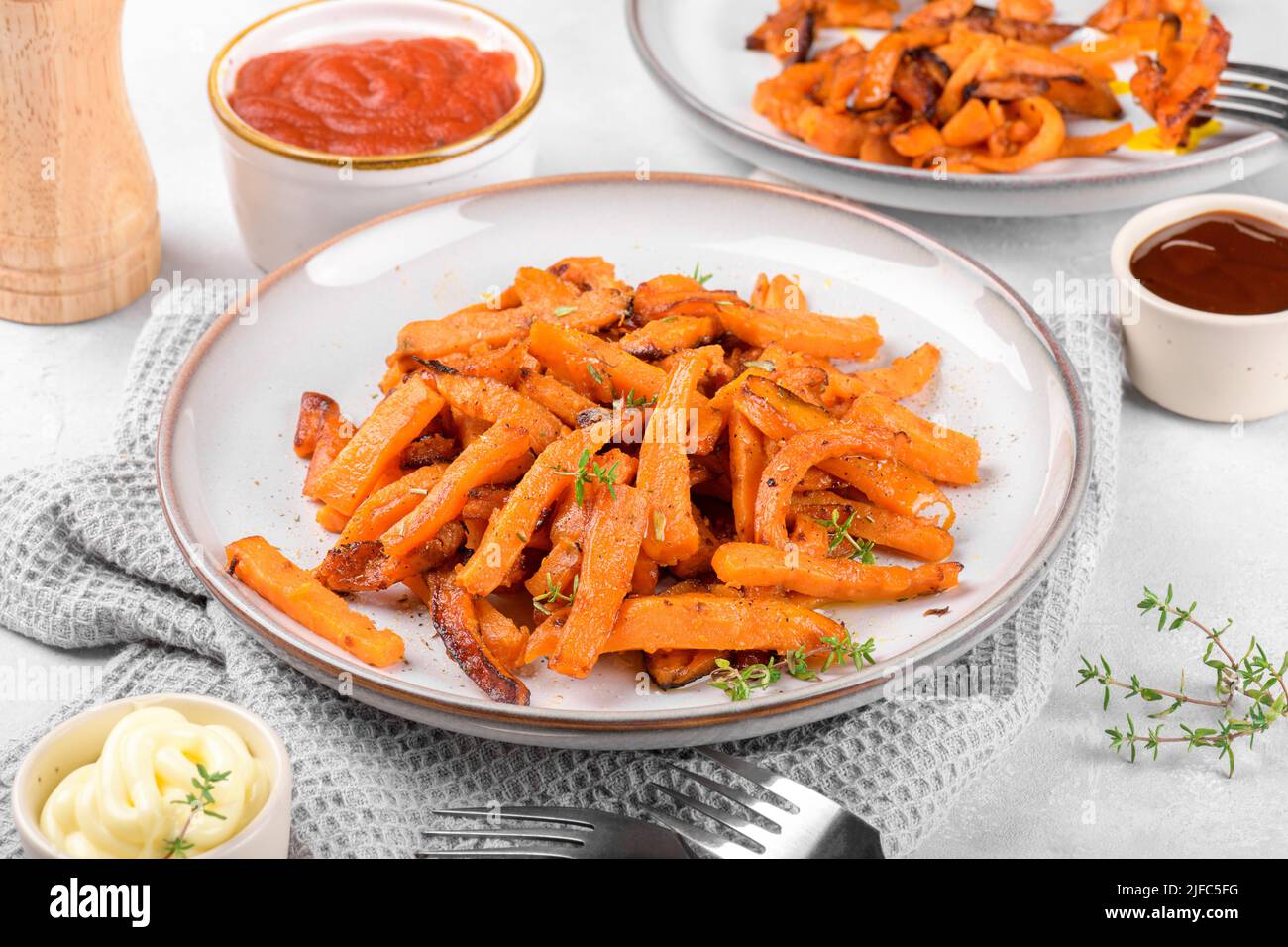Sweet potato fries on a plate with mayo and ketchup, bbq sauce homemade ...