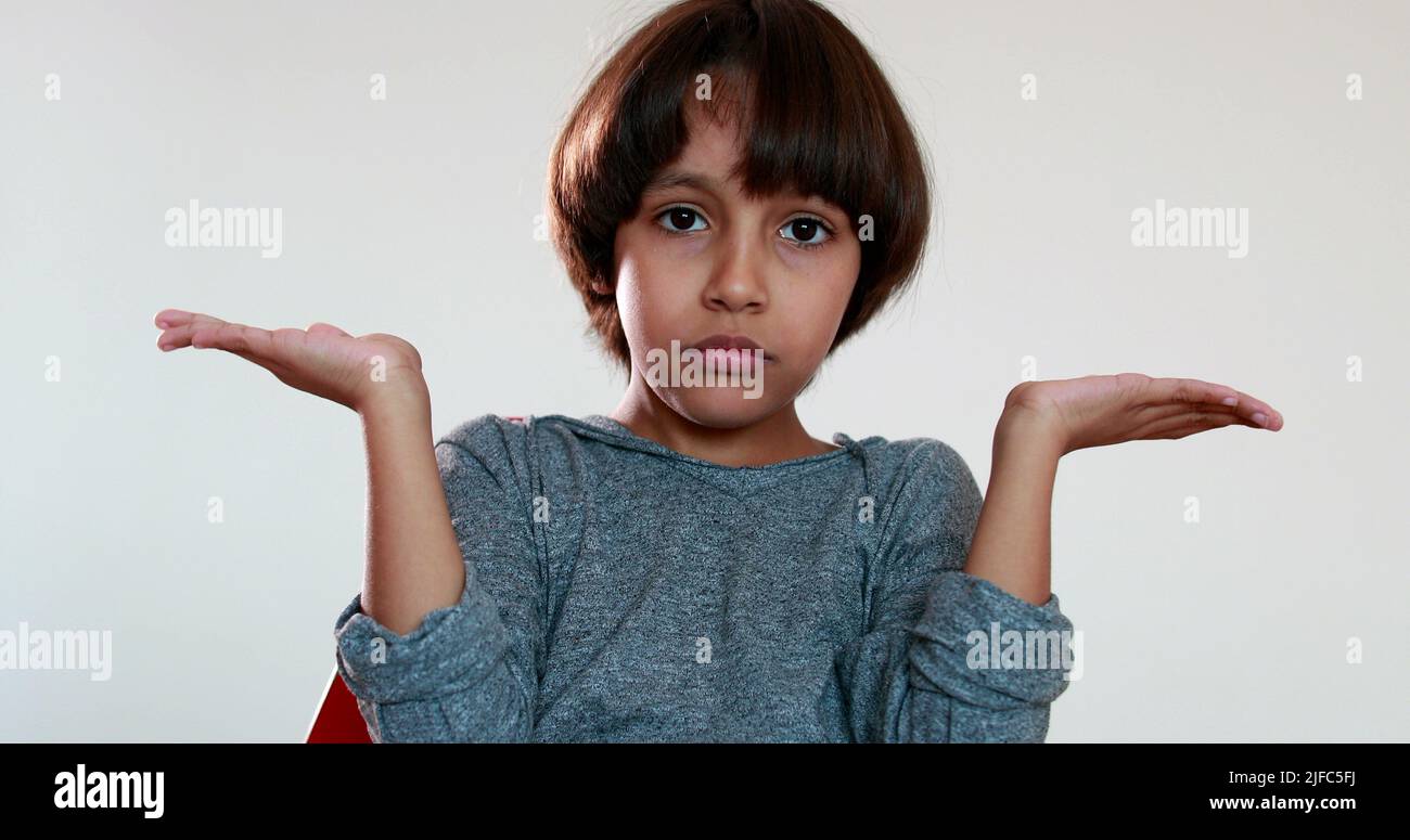 Doubtful young boy child kid. Ethnically diverse showing doubt Stock ...