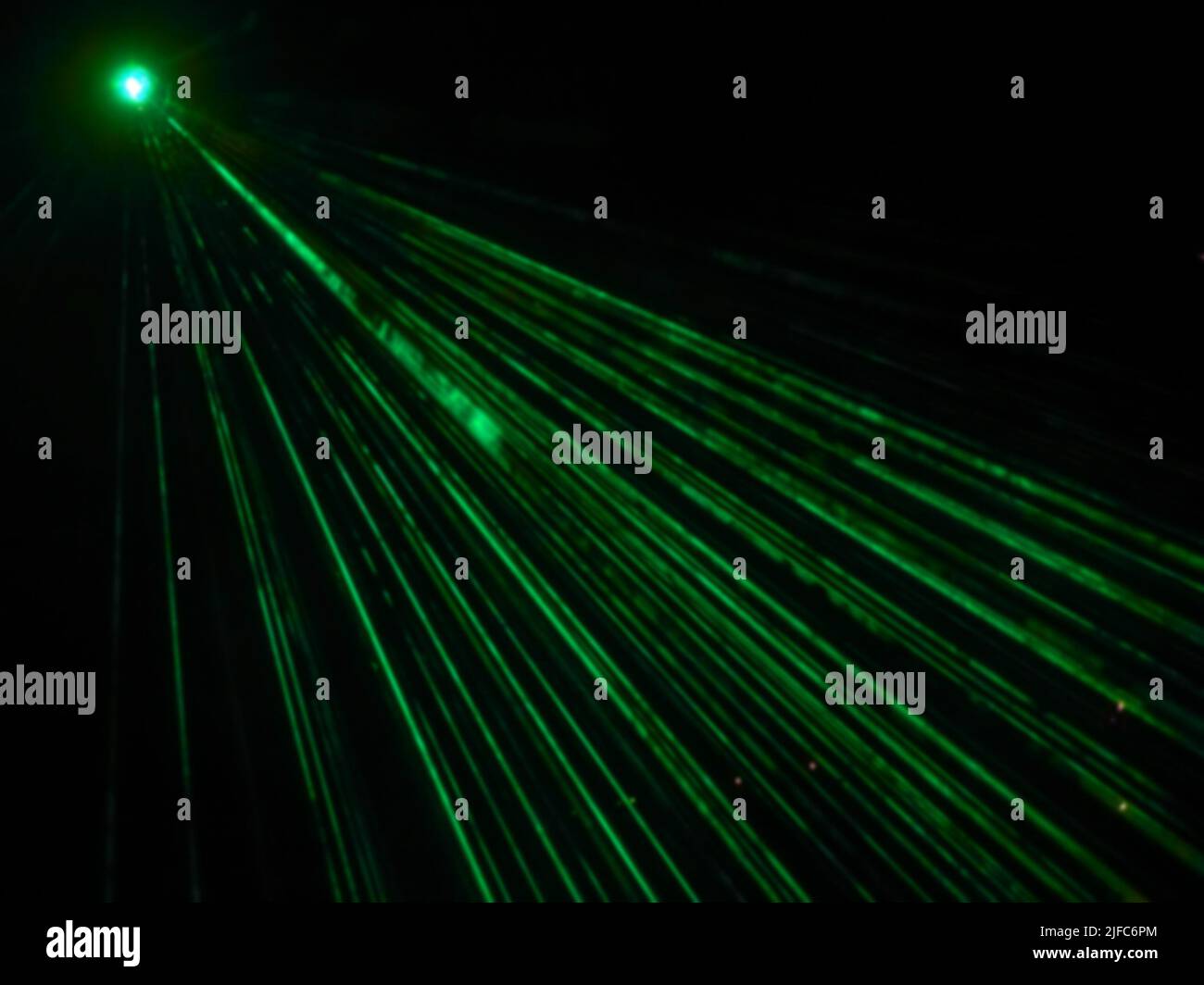 Outdoor projector shines bright green beams in dark. Laser show ...