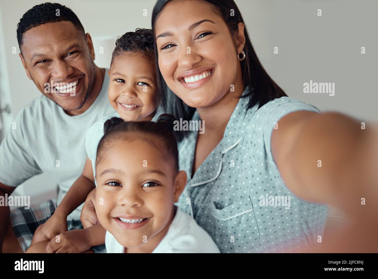 Photo of a loving mother holding phone and taking selfie or recording ...