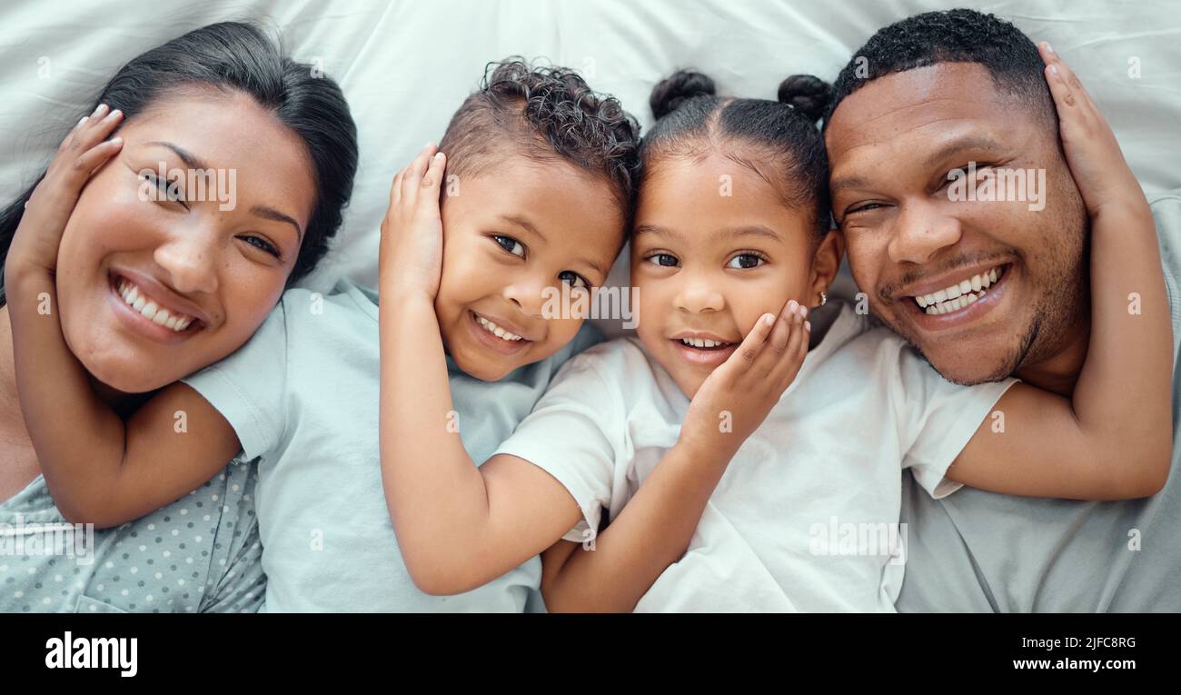 Portrait of happy mixed race family with two children relaxing and ...