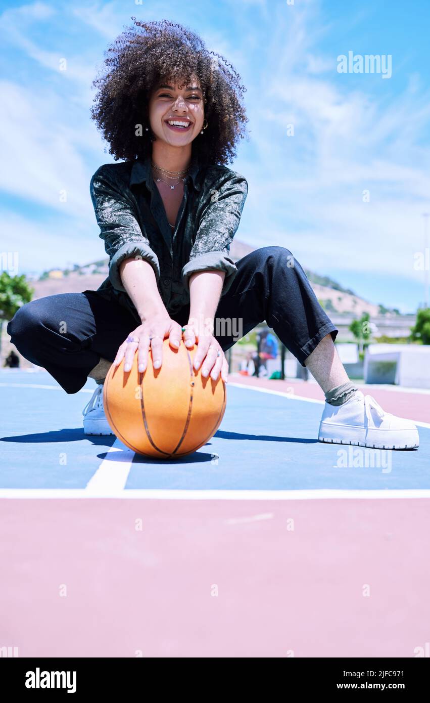 Cheerful young african african woman with curly afro squatting and ...