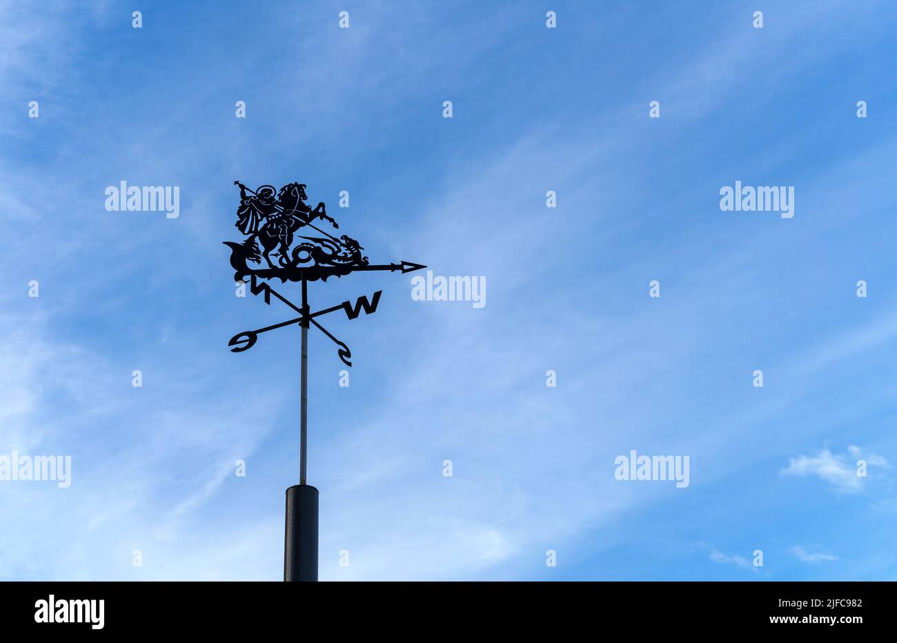 Weather vane showing direction of wind against clear blue sky. Metal ...