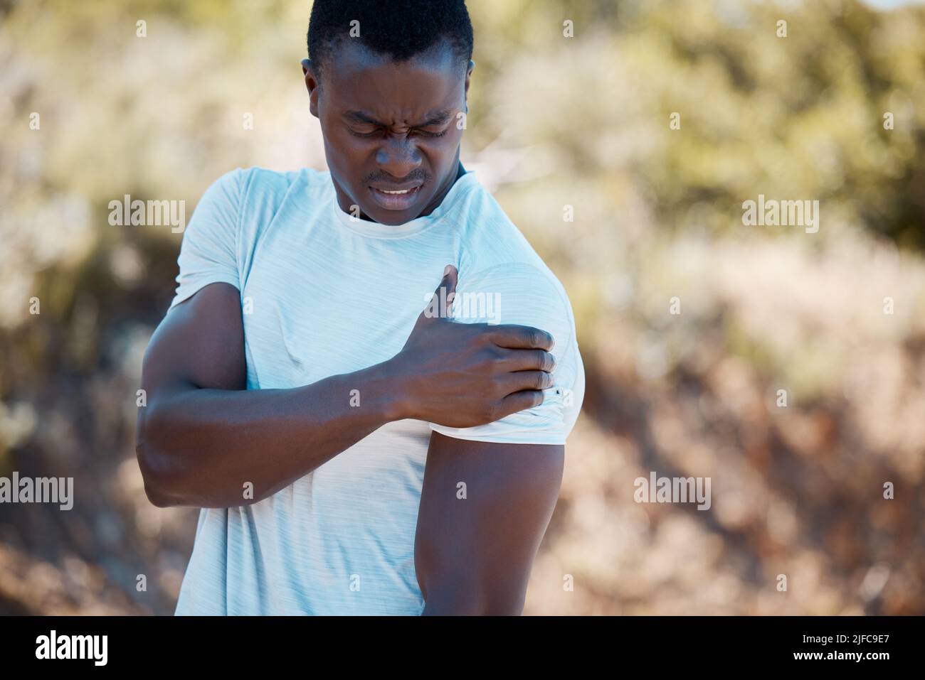 Active african american man holding his shoulder in pain while ...