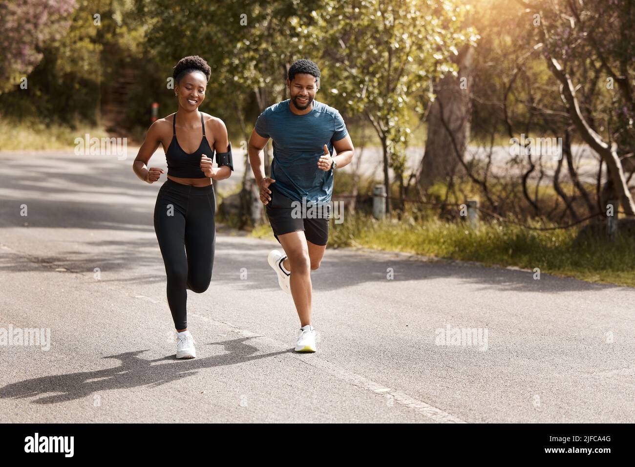 Fit african american couple running outdoors while exercising. Young ...
