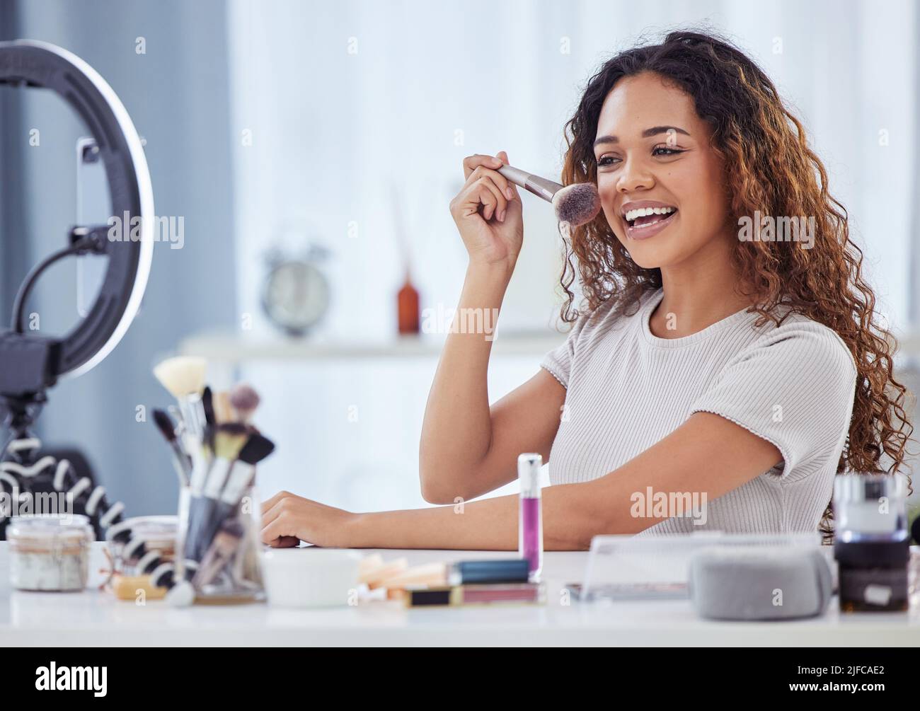 One hispanic woman recording a makeup tutorial for her beauty blog with ...