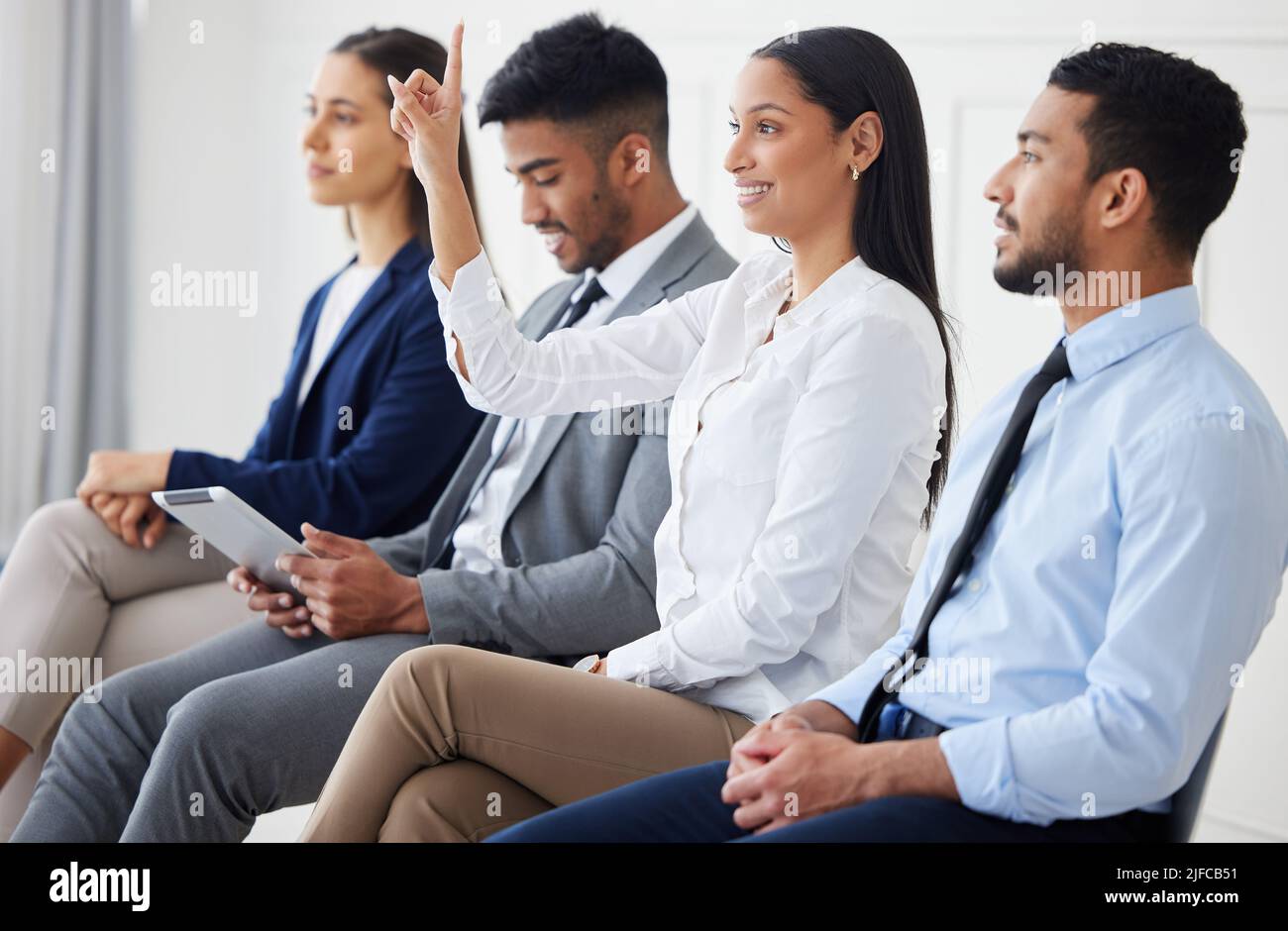 Mixed race businesswoman raising finger to ask question in interview ...