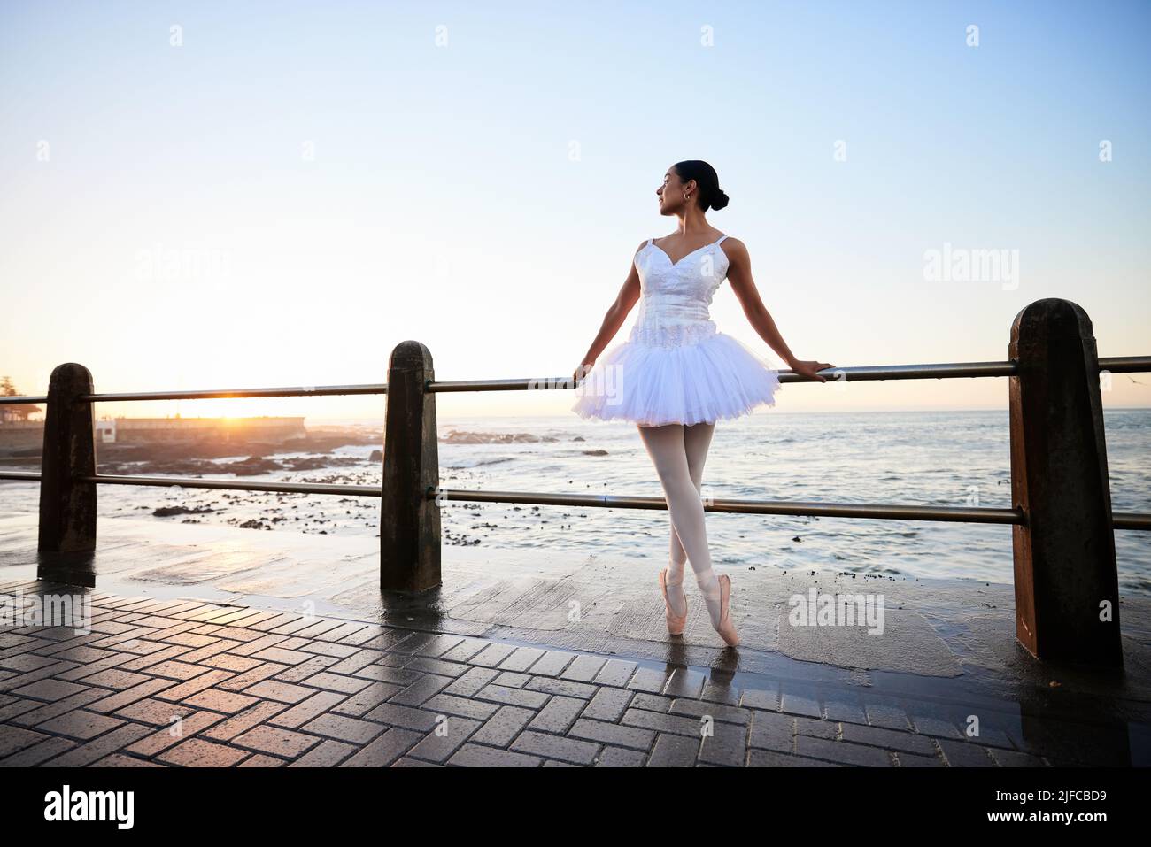 Elegant young ballerina wearing white fancy dress and pumps while ...