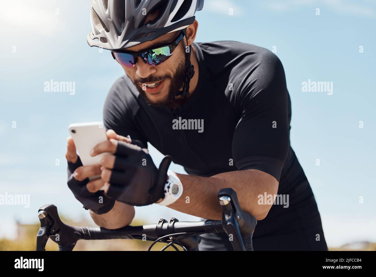 Happy young cyclist wearing helmet and glasses while using his ...