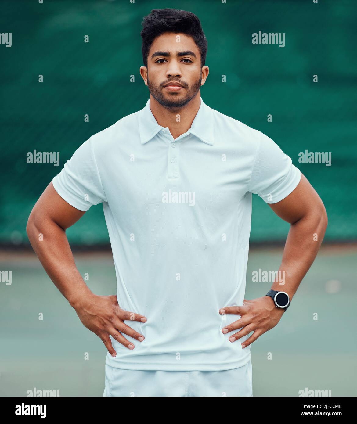 Portrait of serious indian tennis player standing alone on a court. Fit ...