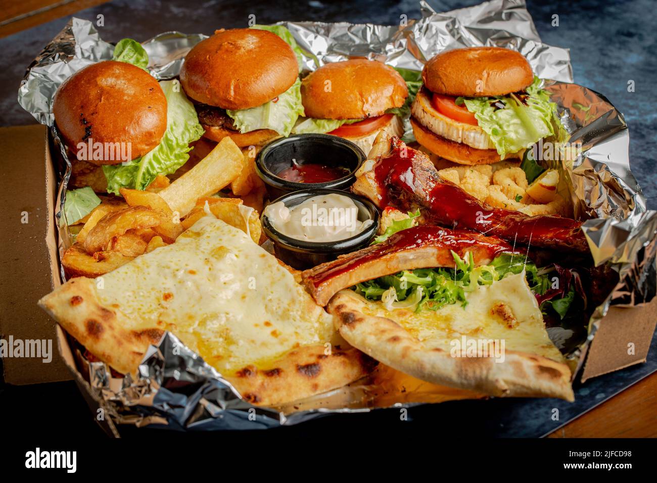 A top view of a fast food meal with burgers, pizza, ribs and fries with ...