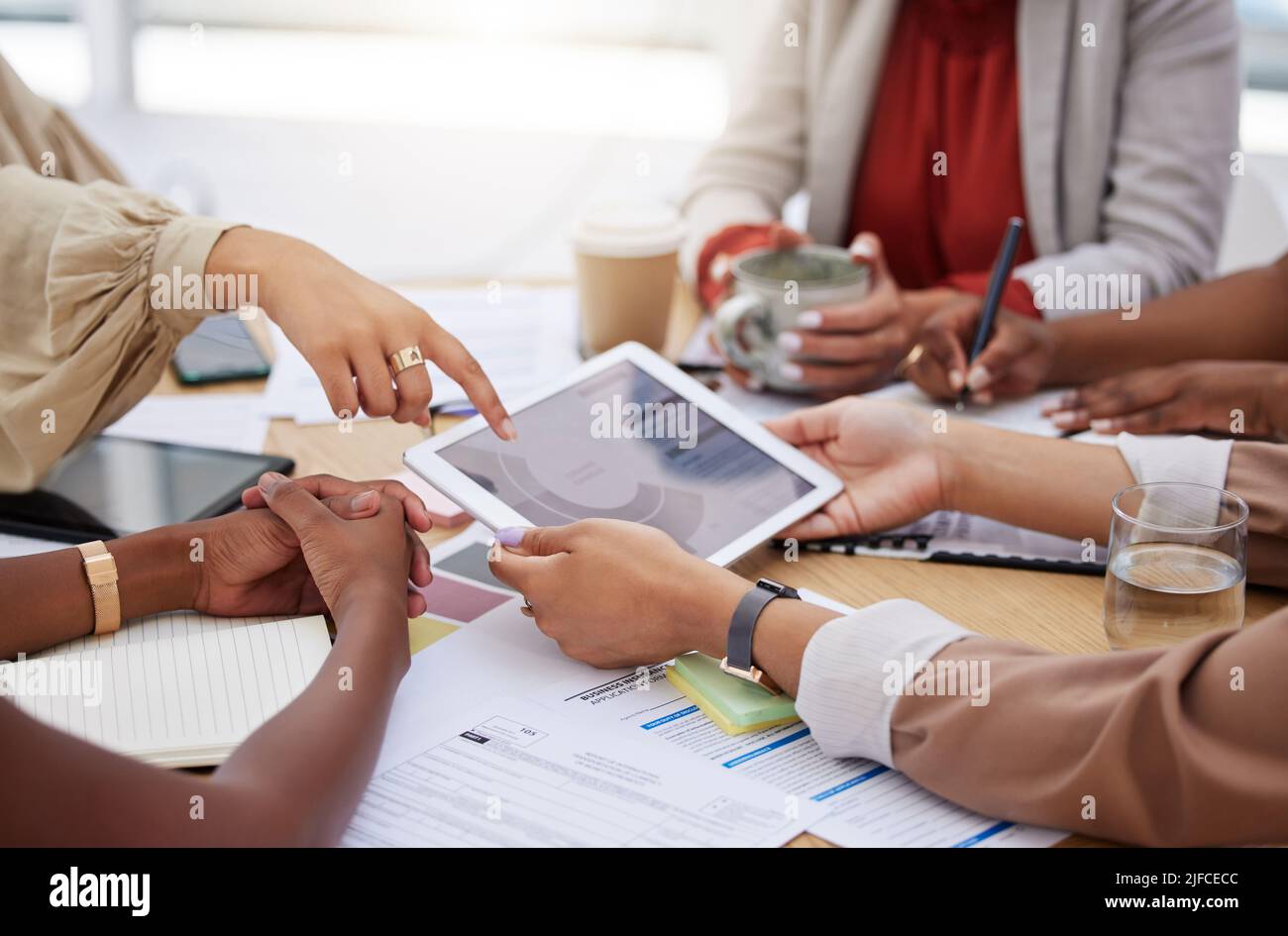 Diverse group of unknown business women using a digital tablet for a ...