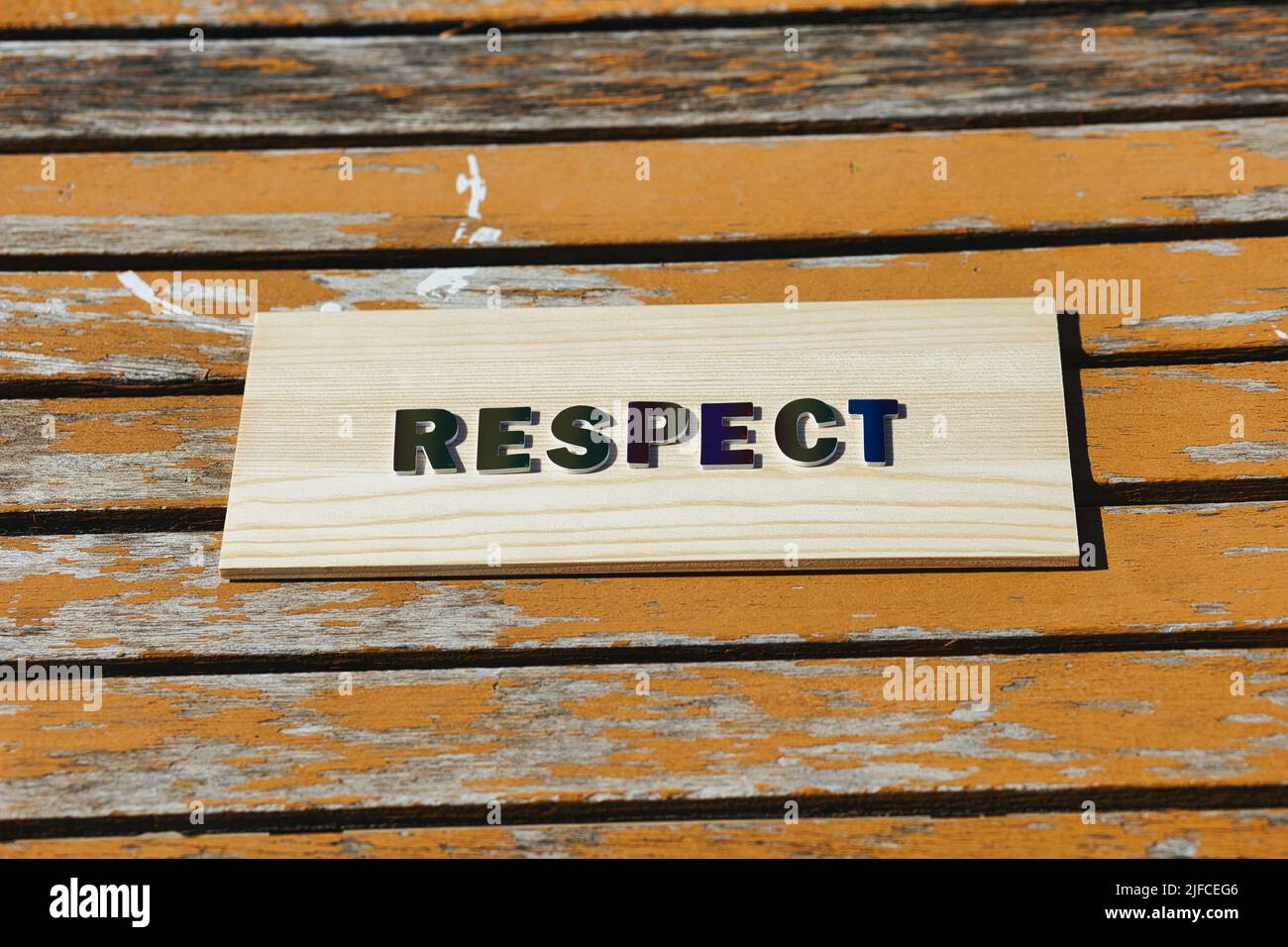 The word Respect in rainbow colored lettering on an old rustic orange ...