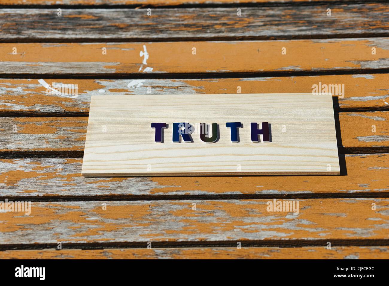 The word Truth in rainbow colored lettering on an old rustic orange ...