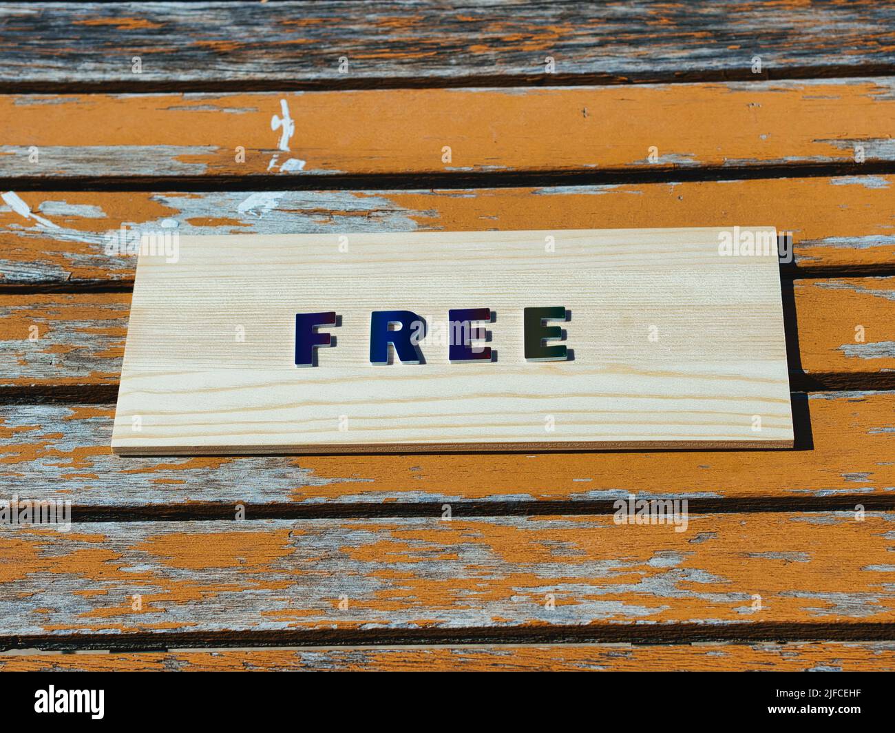 The word "Free" written in rainbow colored lettering on a old rustic ...