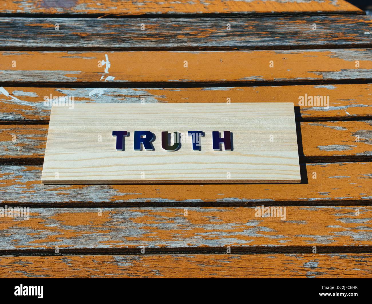 The word Truth in rainbow colored lettering on an old rustic orange ...