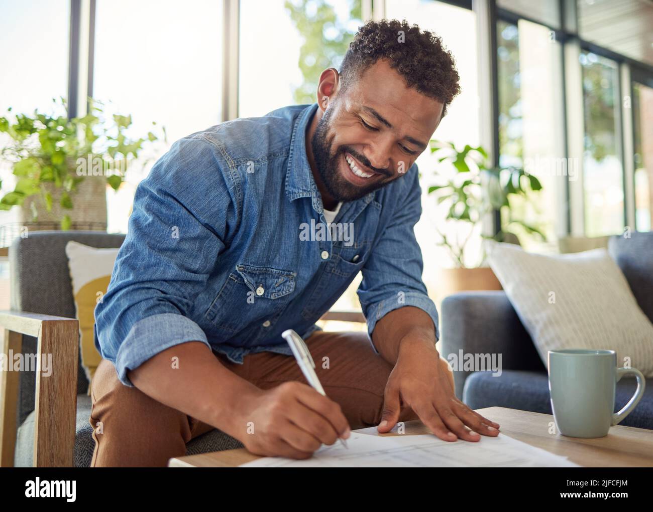 Happy bachelor signing a contract. Man filling out insurance documents ...