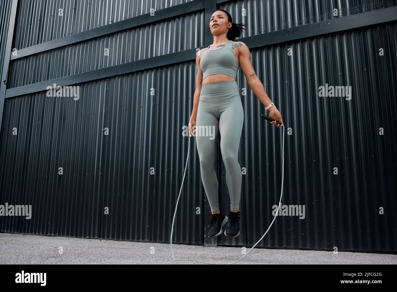 One young african american female athlete skipping using jump rope ...