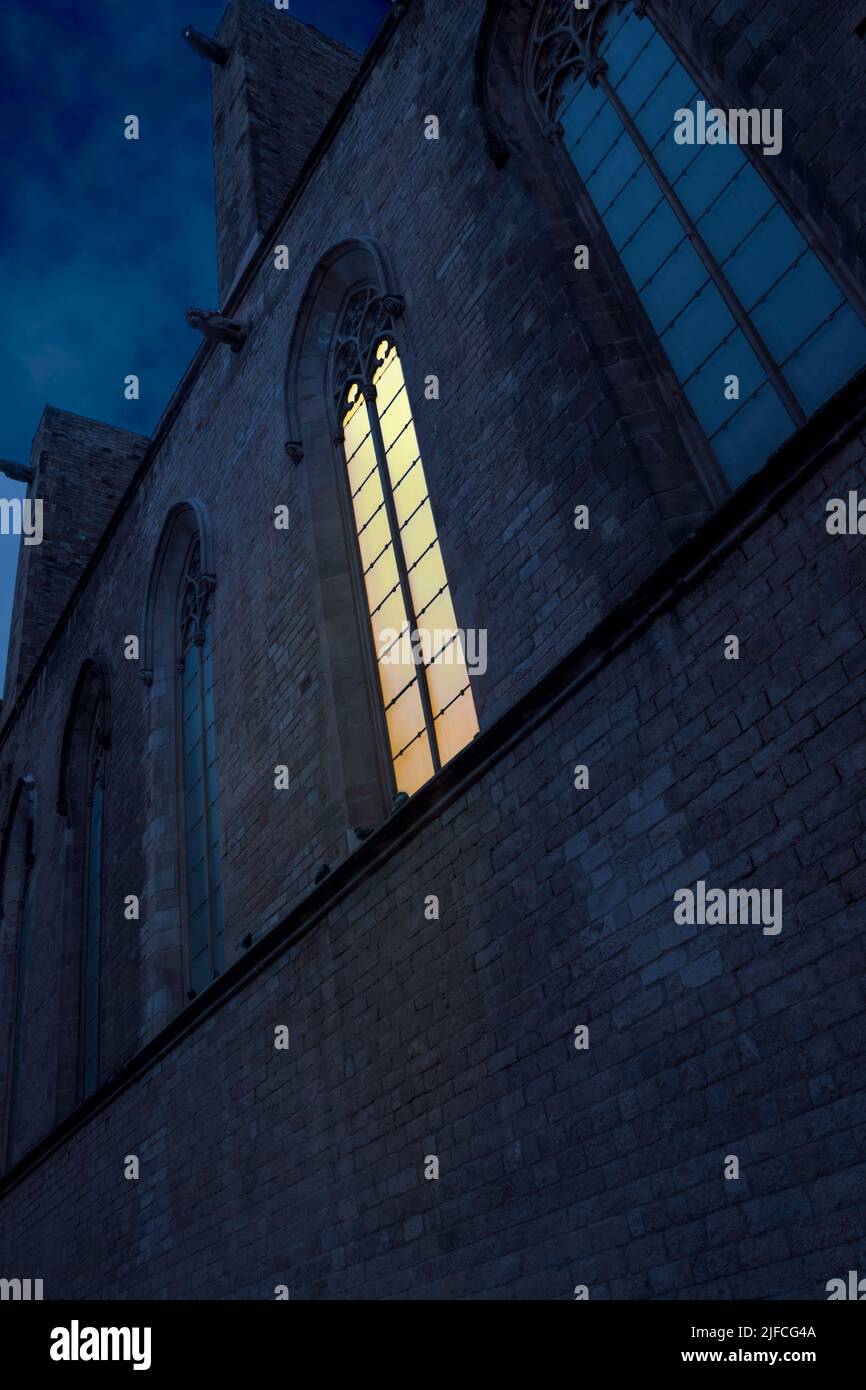 Dark cathedral with one lit window Stock Photo - Alamy